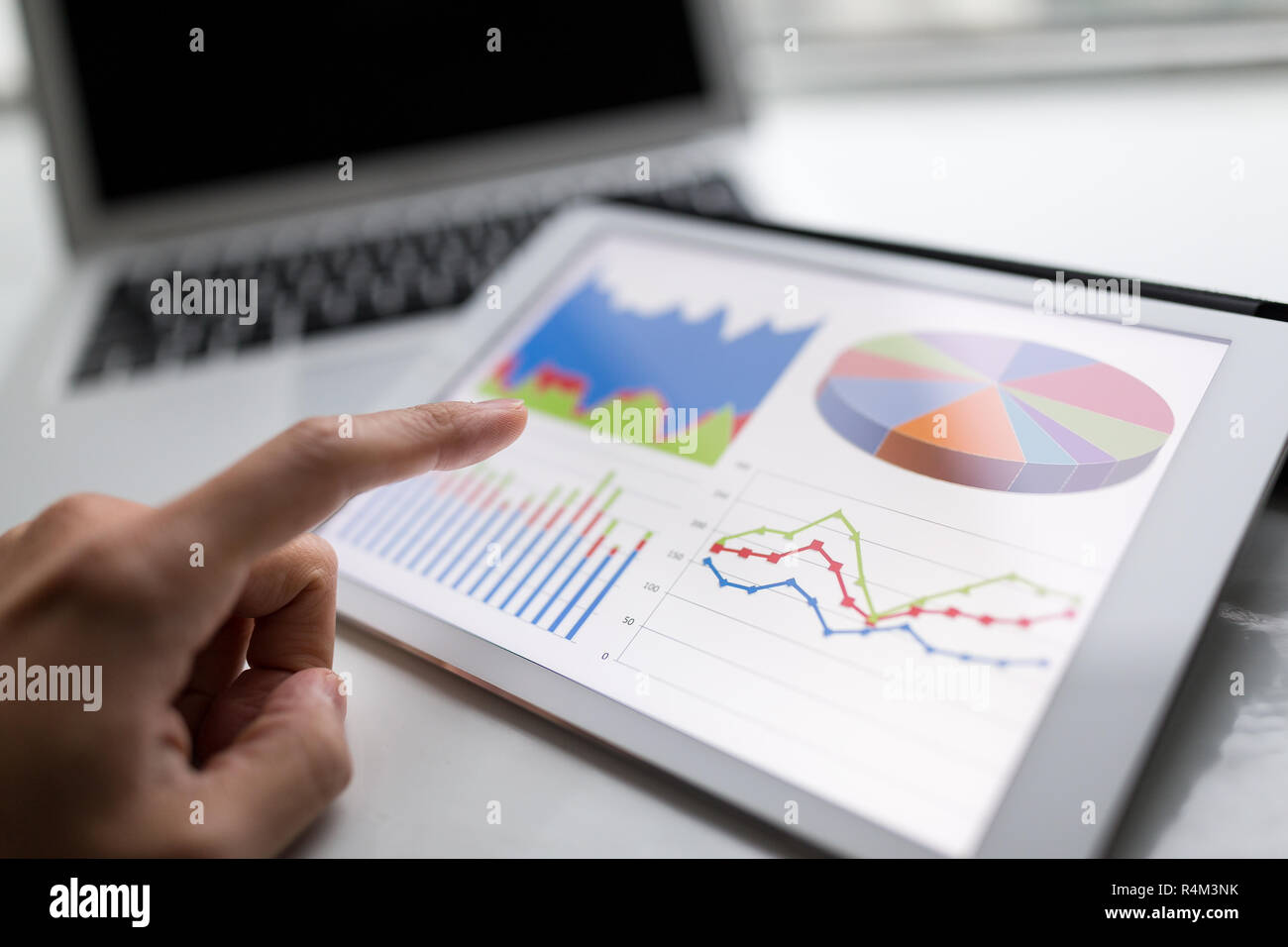 Finger touch on digital tablet with chart Stock Photo - Alamy