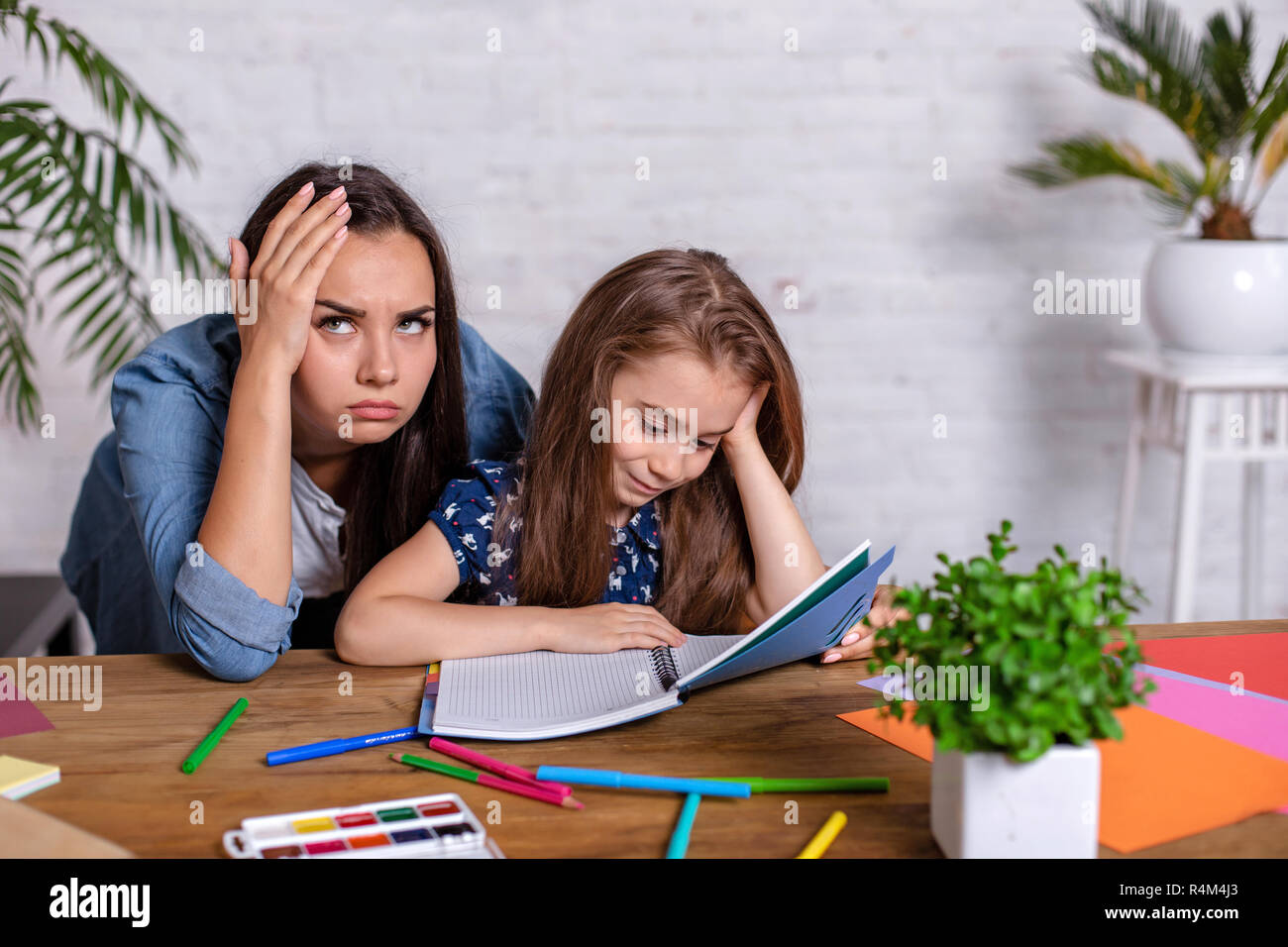 Mother becoming frustrated with daughter whilst doing homework sitting ...