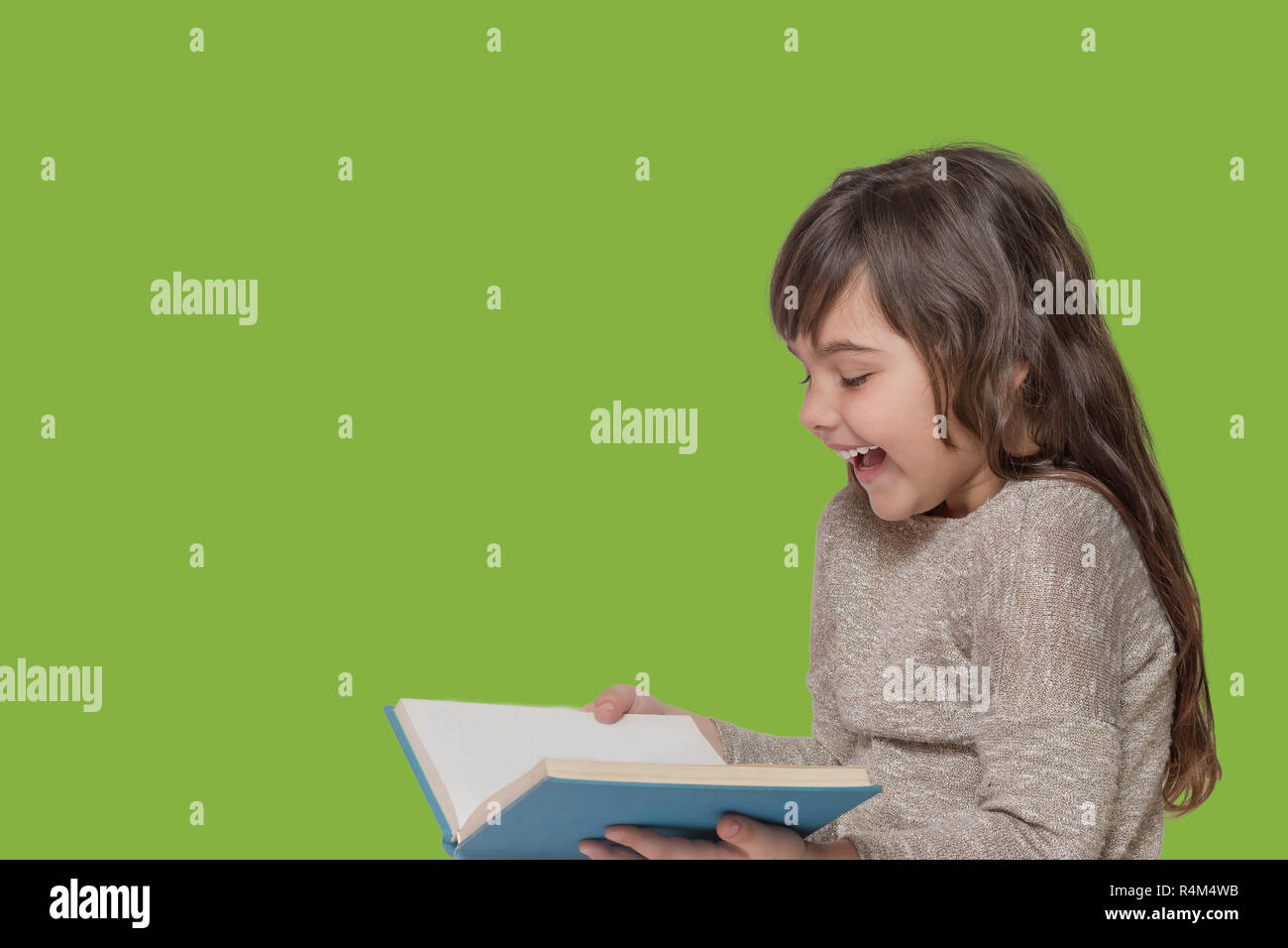 Smiling little girl holding open book Stock Photo - Alamy