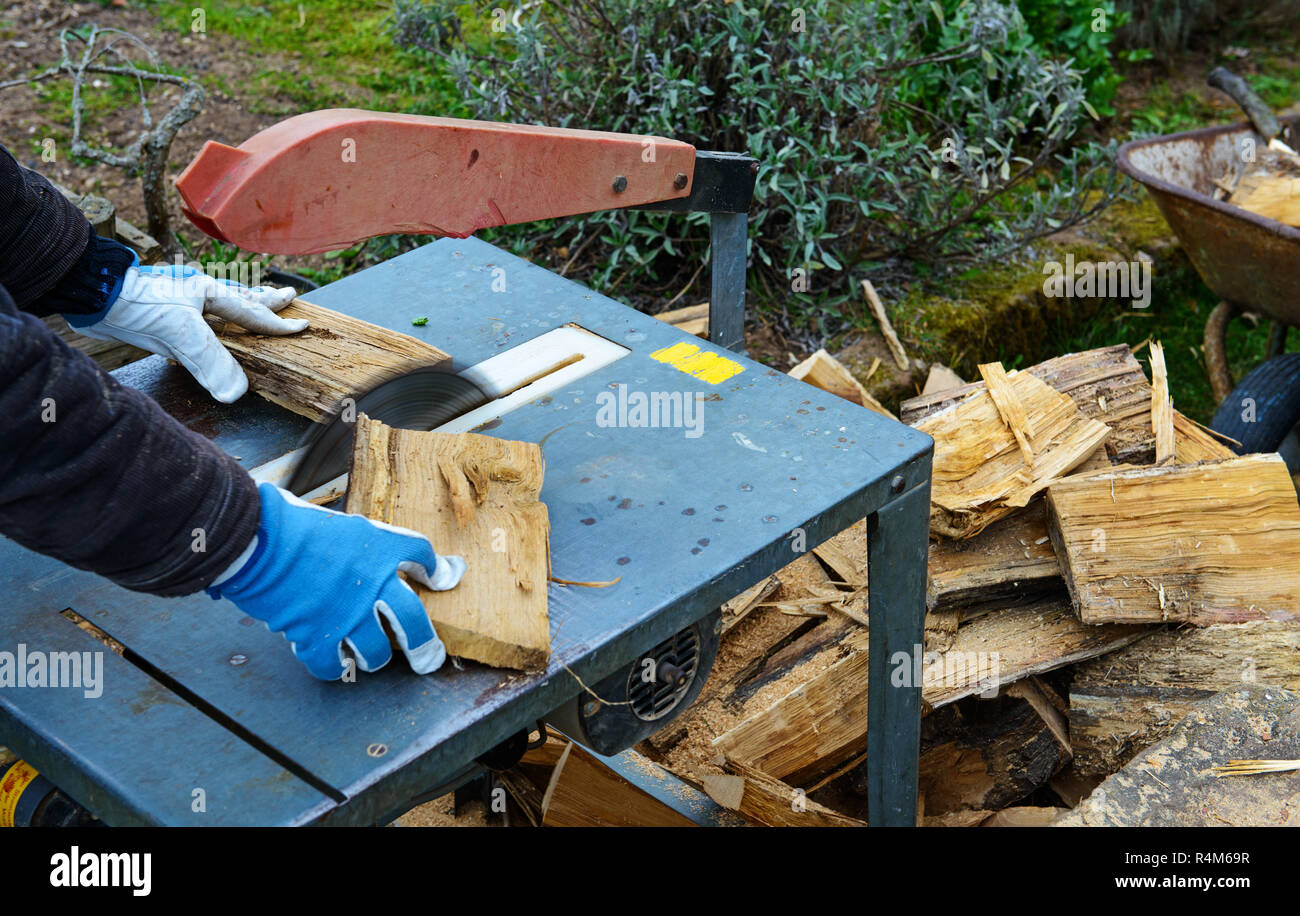 man making firewood with buzz saw Stock Photo - Alamy