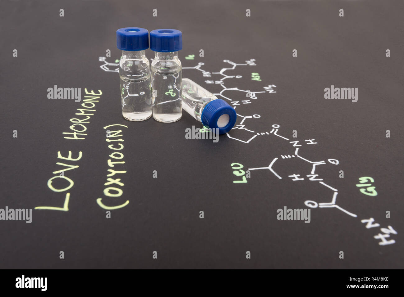 Close-up blue cap sample vial on paper with chemical formula of ...