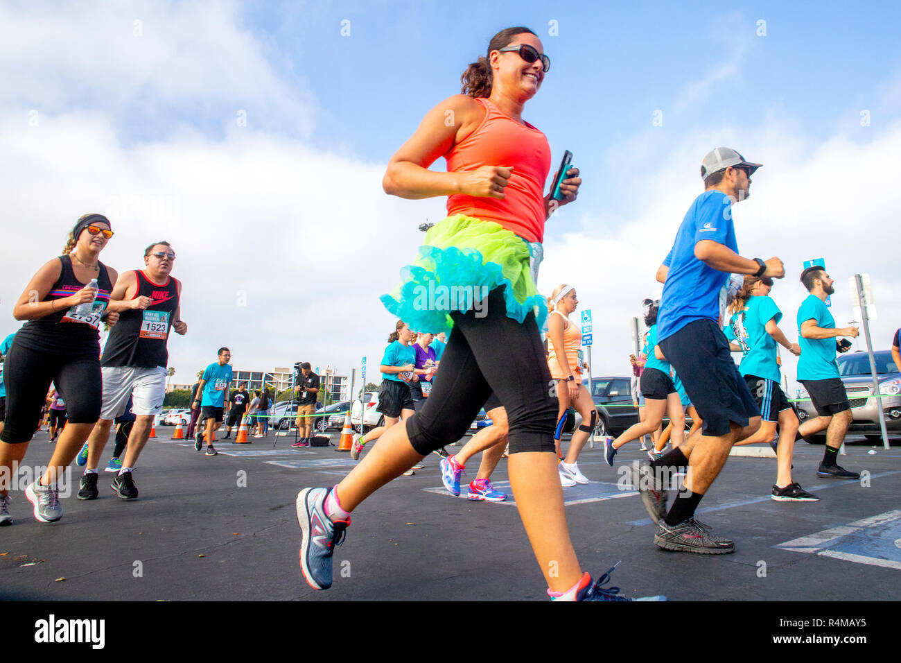 Participants in a 5K "Fun Run" race through a fairground parking lot in ...