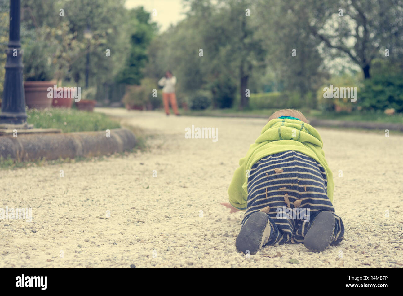 Rear view of a baby crawling towards her mother outdoor Stock Photo - Alamy