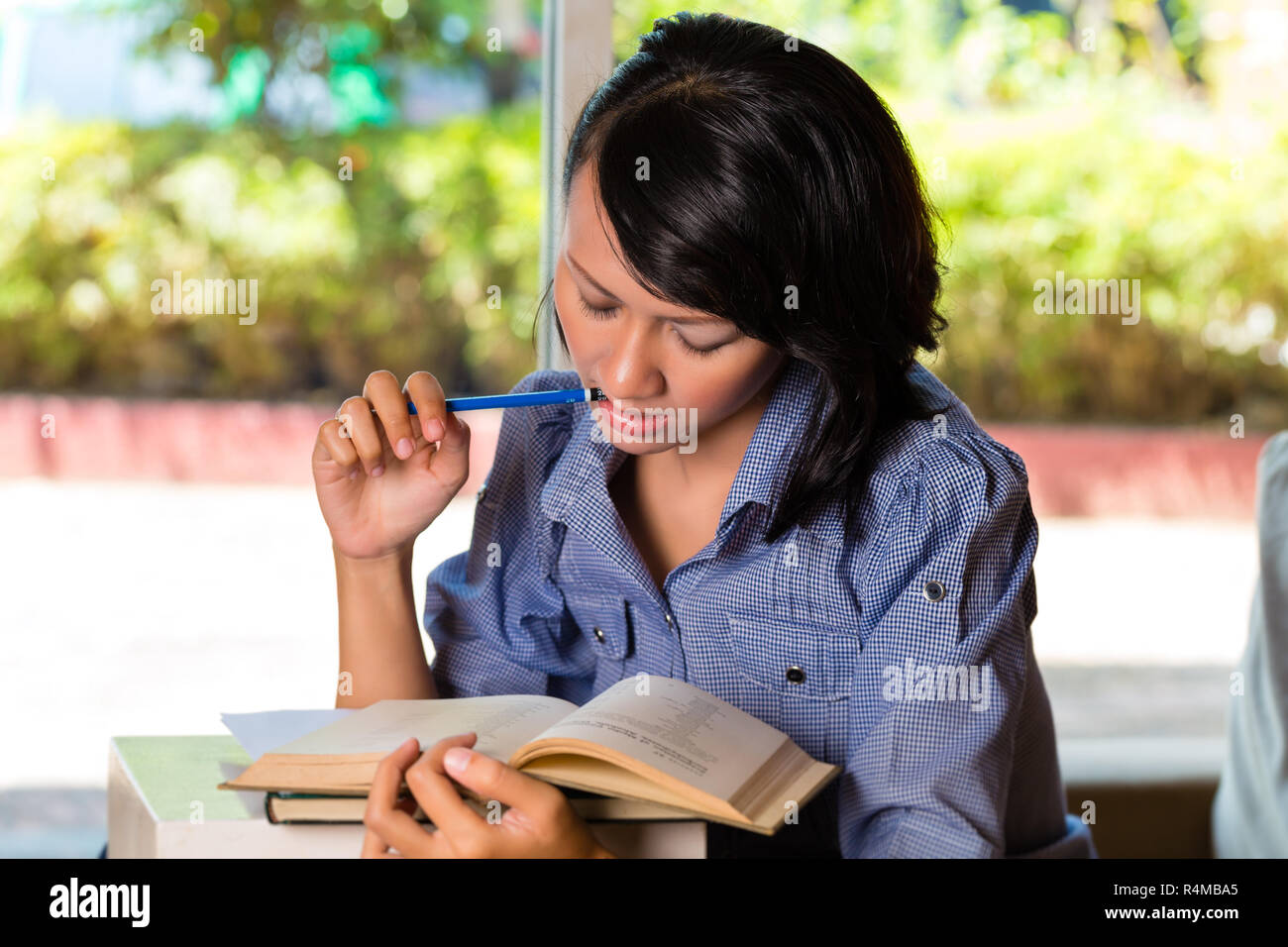Girl with pile of books learning Stock Photo - Alamy