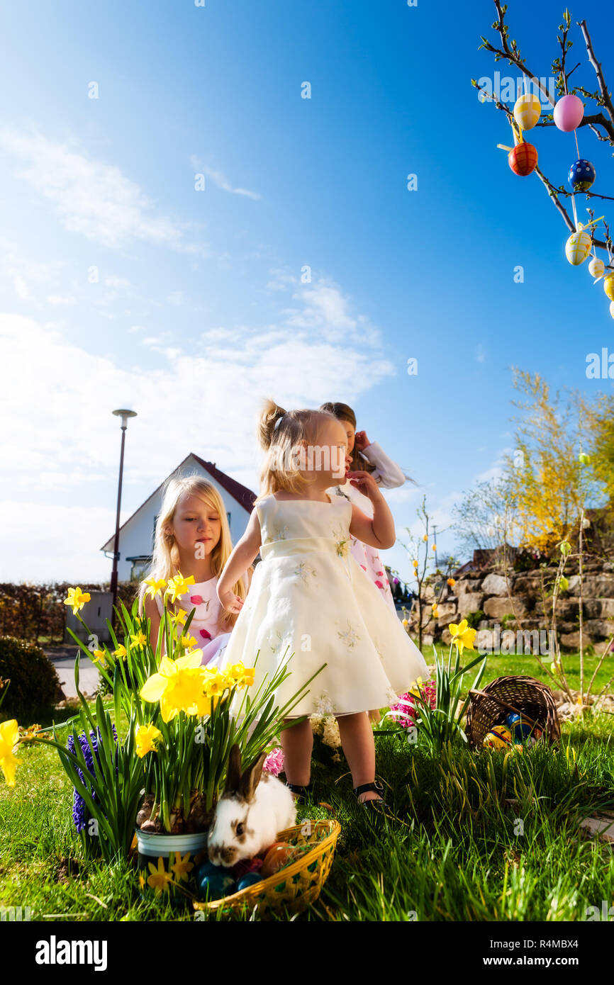 Children on Easter egg hunt with bunny Stock Photo - Alamy