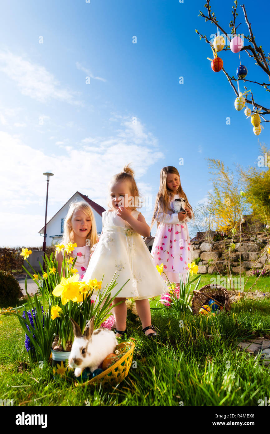 Children on Easter egg hunt with bunny Stock Photo - Alamy