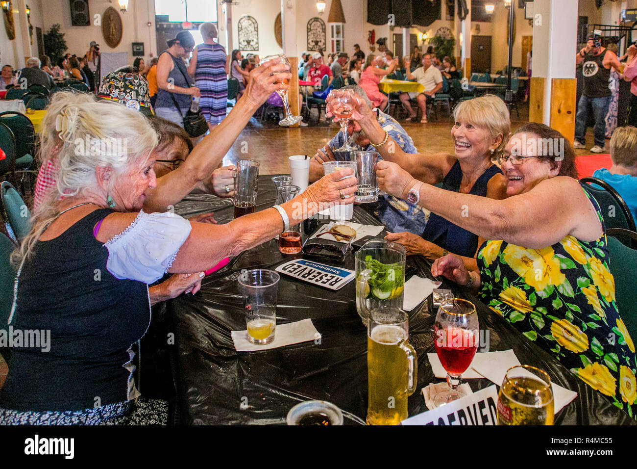 Four senior women toast each other with beer at an ethnic German ...