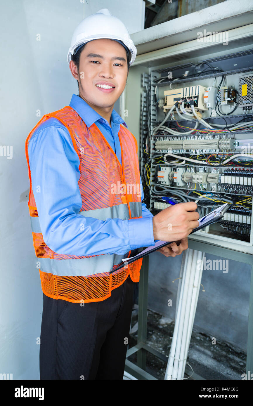 Asian Electrician at panel on construction site Stock Photo - Alamy