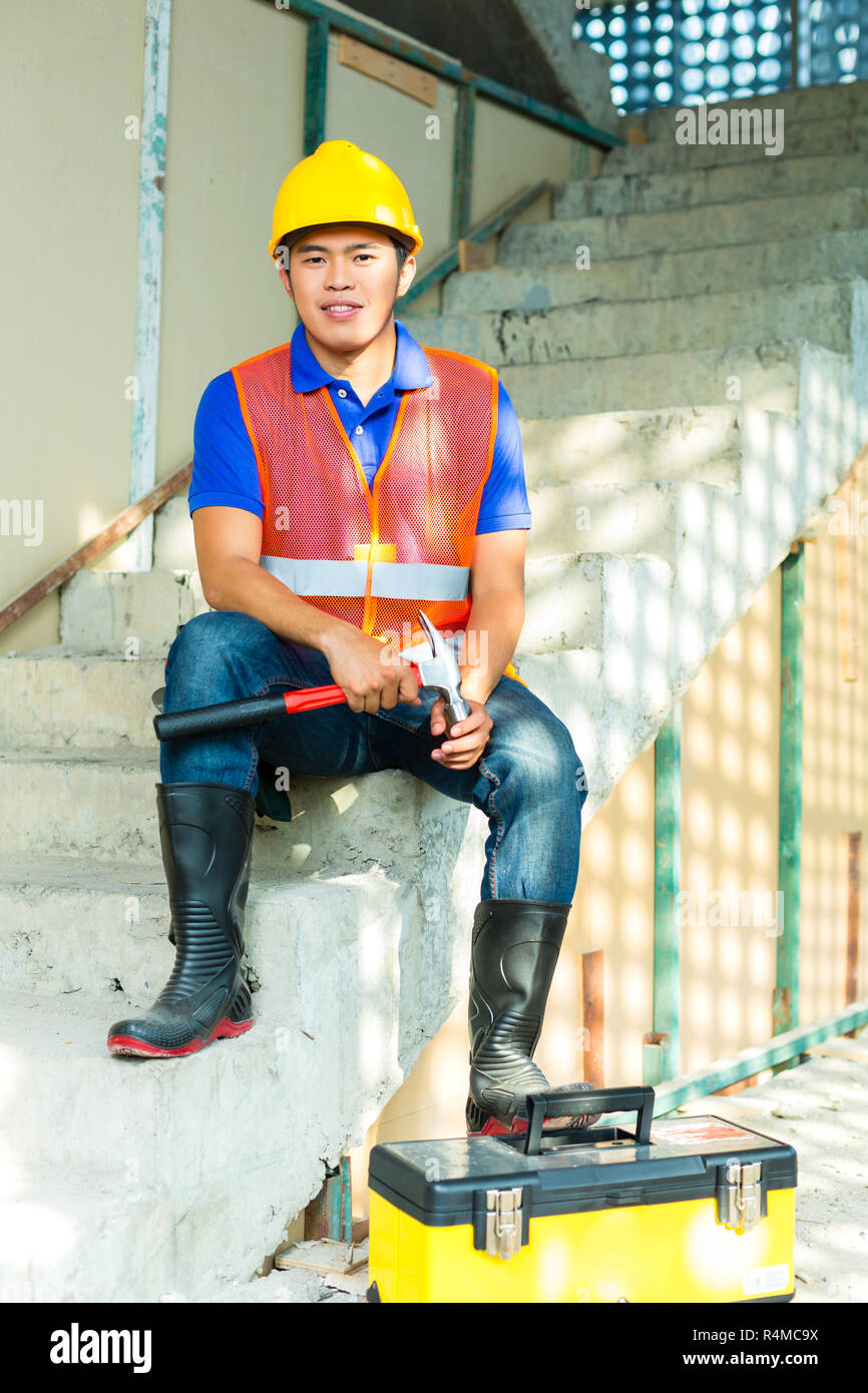 Asian Indonesian construction worker on building site Stock Photo - Alamy