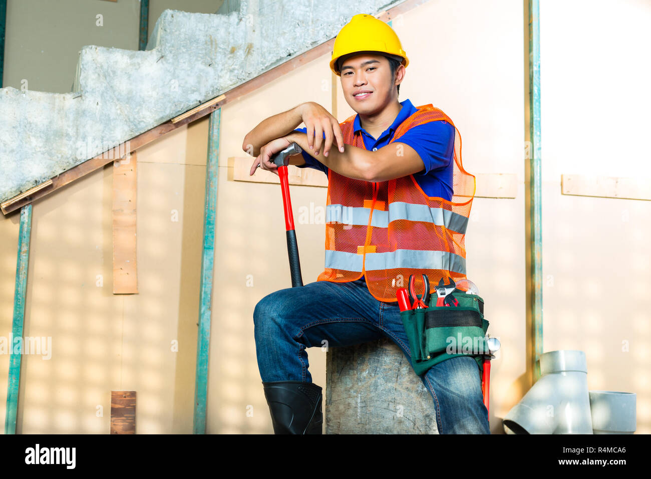 Asian Indonesian construction worker on building site Stock Photo - Alamy