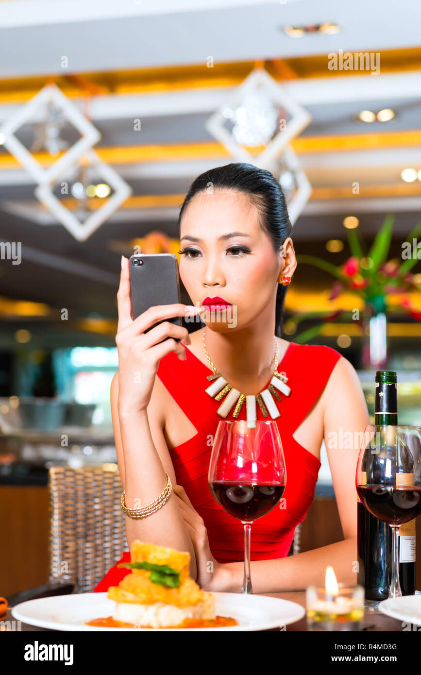 Young Asian woman sitting in restaurant Stock Photo - Alamy