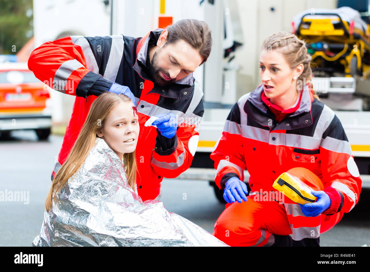 Ambulance doctor helping injured woman Stock Photo - Alamy