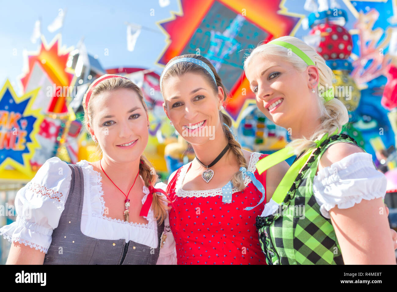 Friends visiting Bavarian fair having fun at carousel Stock Photo - Alamy