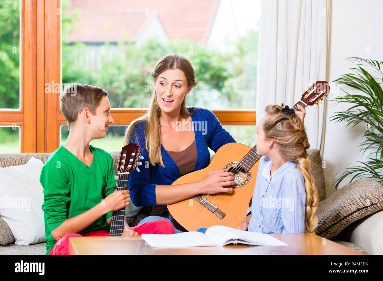 Family making music with guitar Stock Photo - Alamy