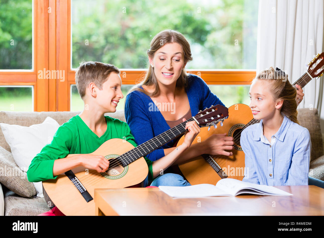 Family making music with guitar Stock Photo - Alamy