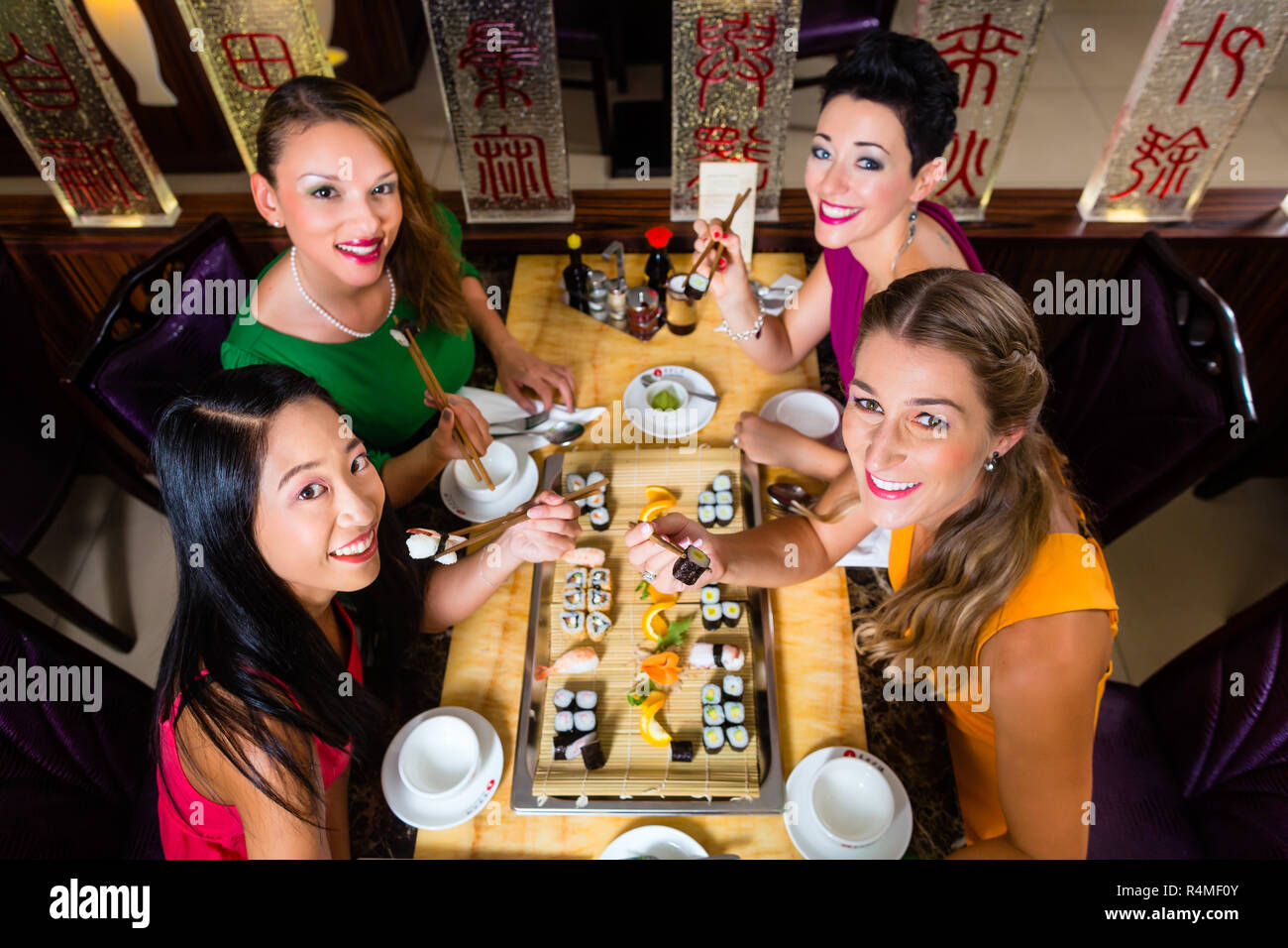 Young people eating sushi in Asian restaurant Stock Photo - Alamy