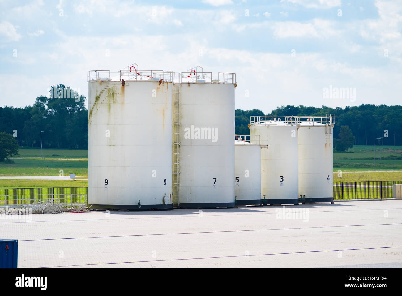 several white storage tanks of a container terminal Stock Photo - Alamy