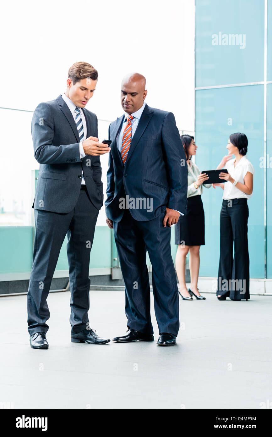 Mixed Asian and Caucasian business team meeting Stock Photo - Alamy