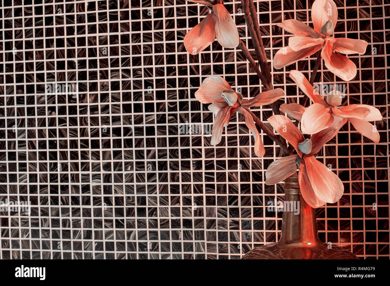 Closeup of bright pink flowers in vase with tiles wall dark background ...