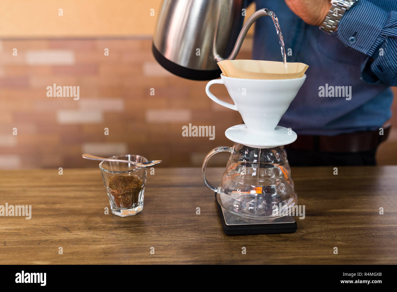 Barista pouring water on coffee ground with filter Stock Photo - Alamy