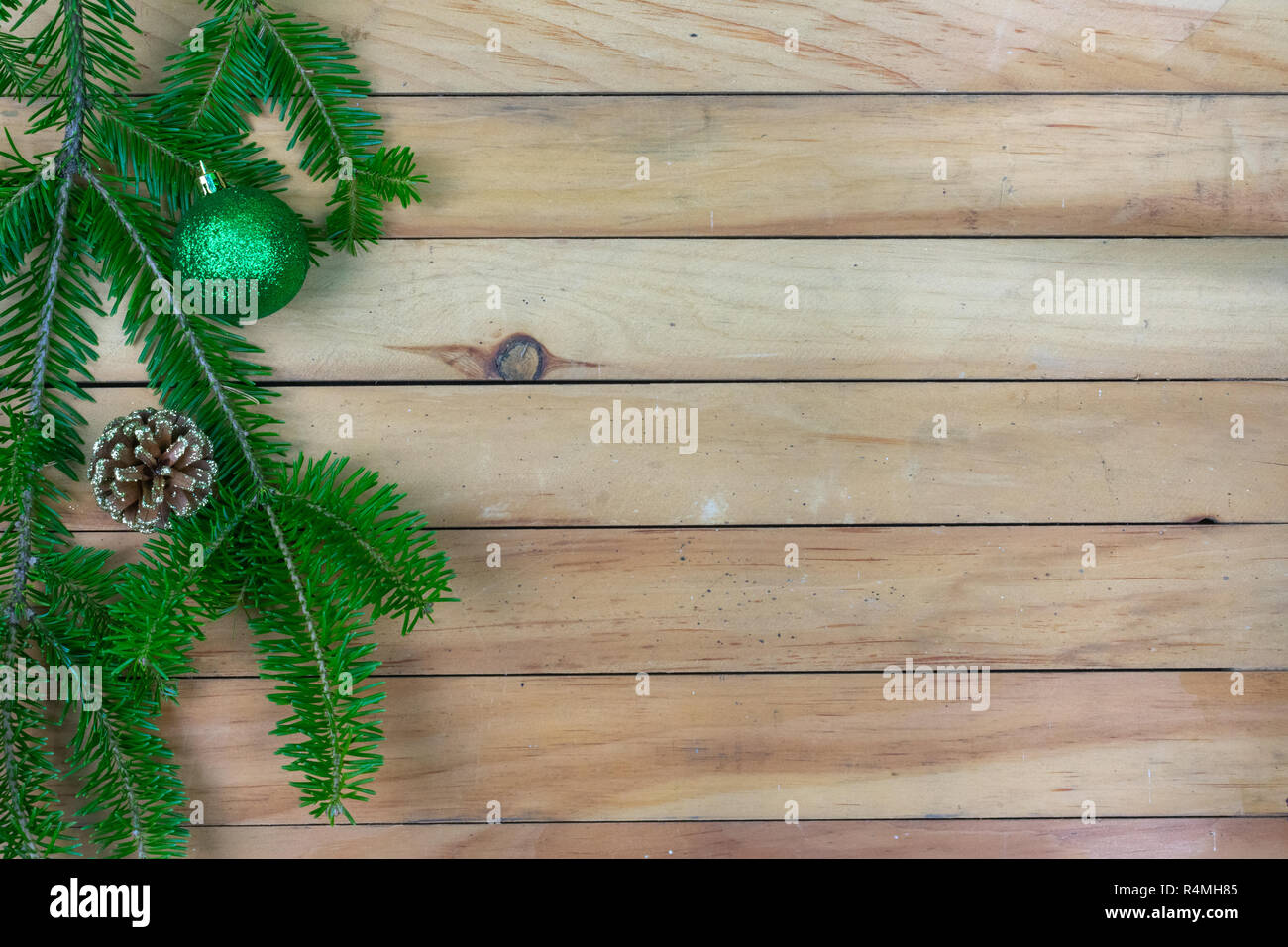 A spruce bough with a glittered pine cone and green ornament on a ...