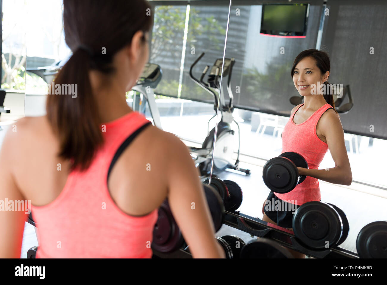 Woman lifting up dumbbell in gym Stock Photo - Alamy