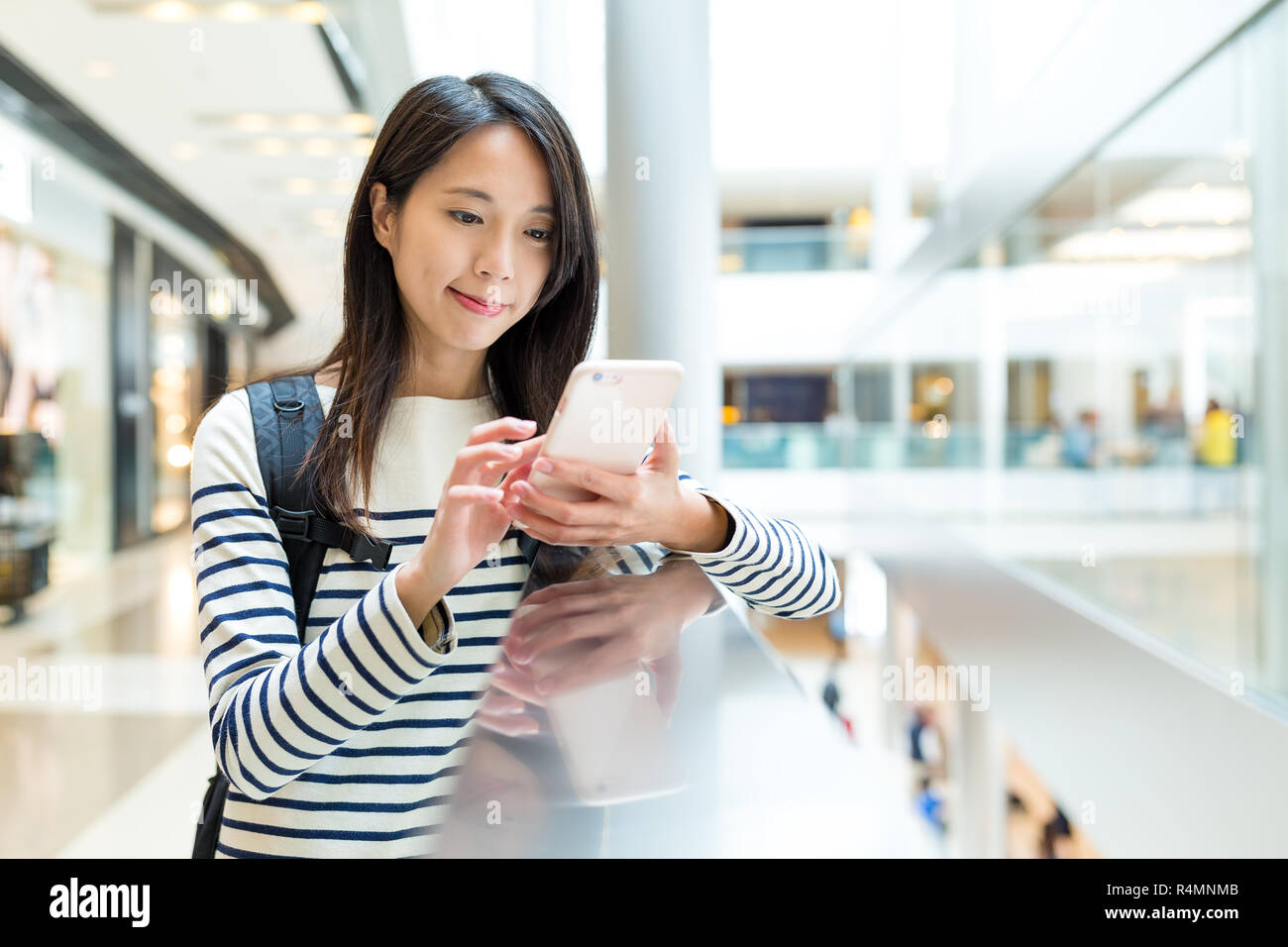 Woman use of mobile phone in shopping mall Stock Photo - Alamy