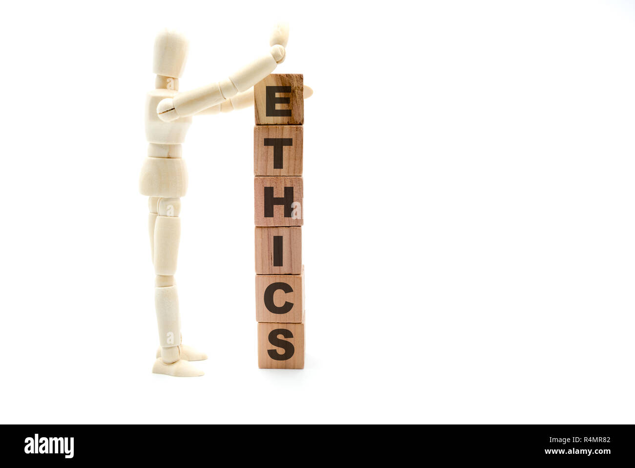 Wooden figure as businessman building Ethics as tower of wood cubes ...