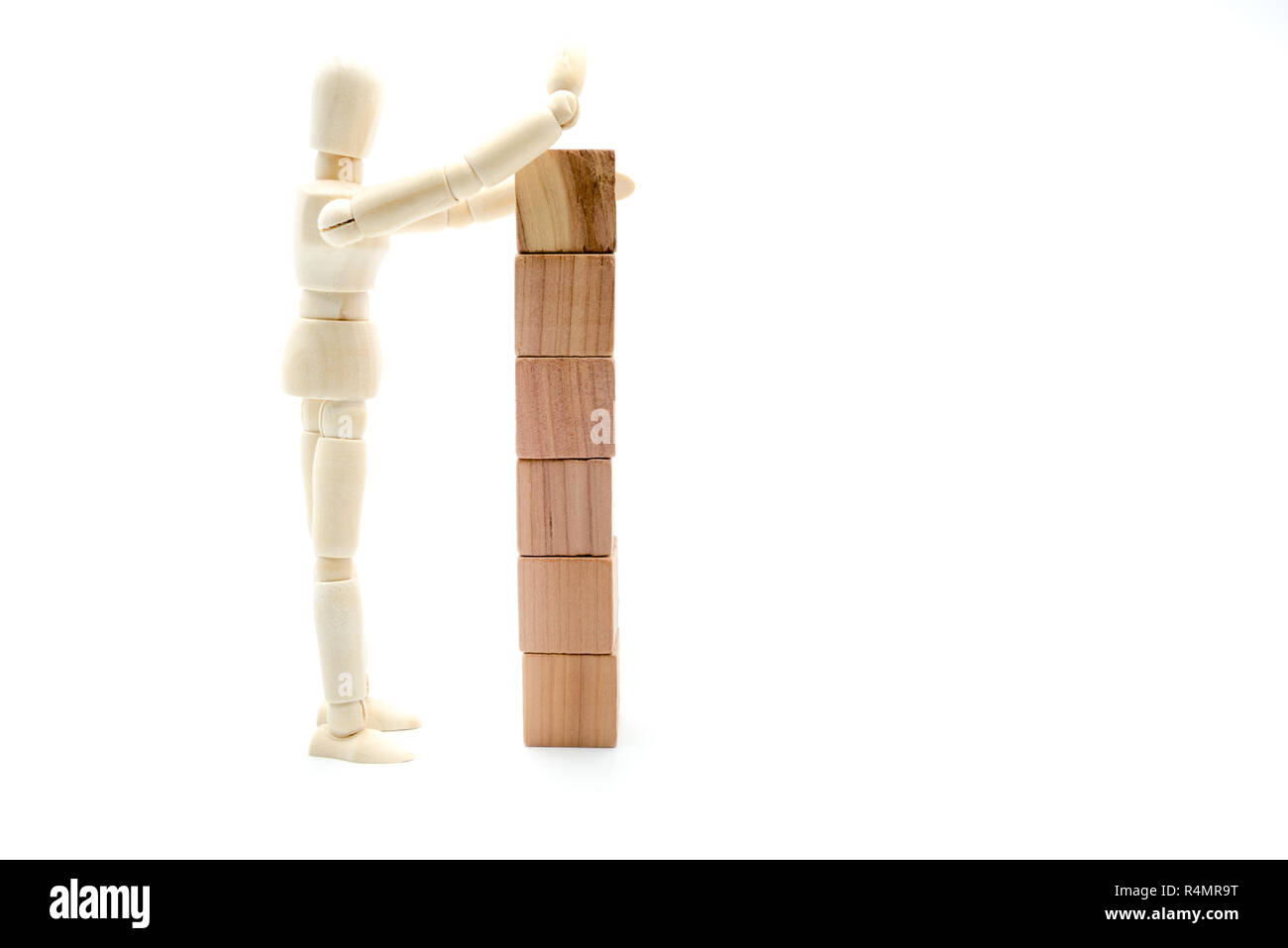 Wooden figure as businessman building tower of wood cubes, isolated on ...