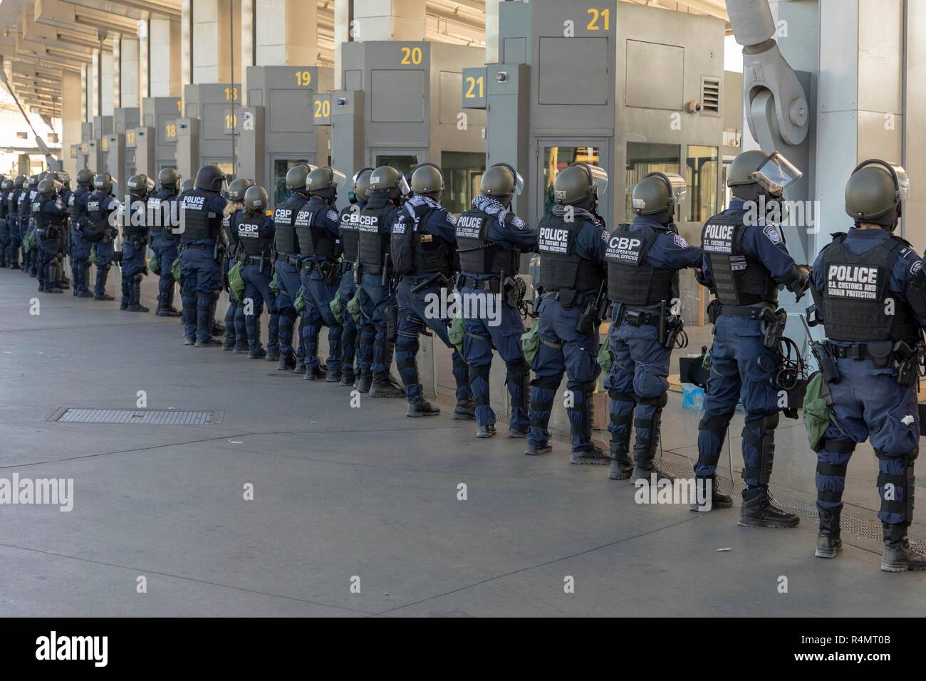 U.S. Customs and Border Patrol agents in riot gear shut the border into ...