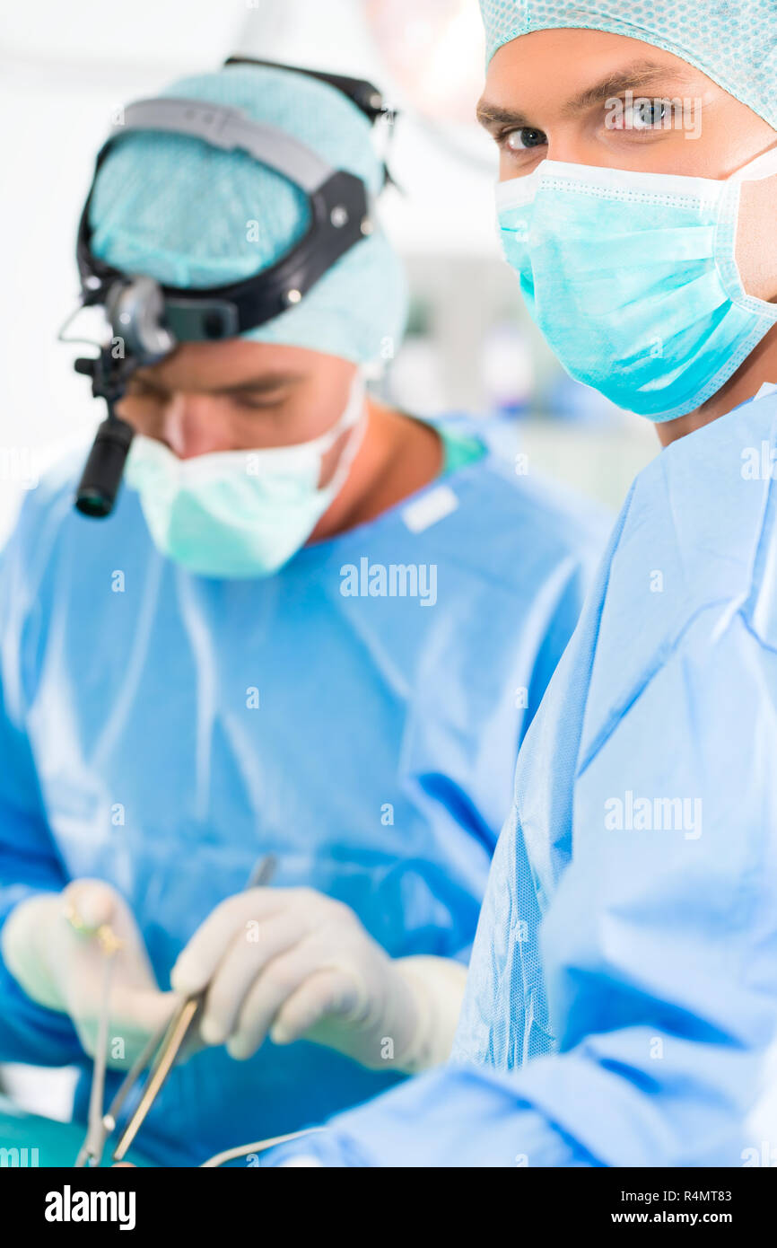 Surgeons operating patient in operation theater Stock Photo - Alamy