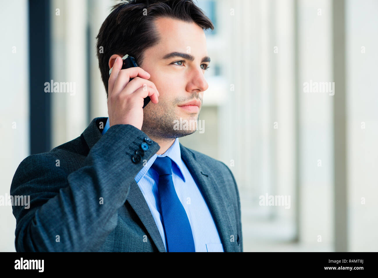 Confident businessman outdoor using phone Stock Photo - Alamy