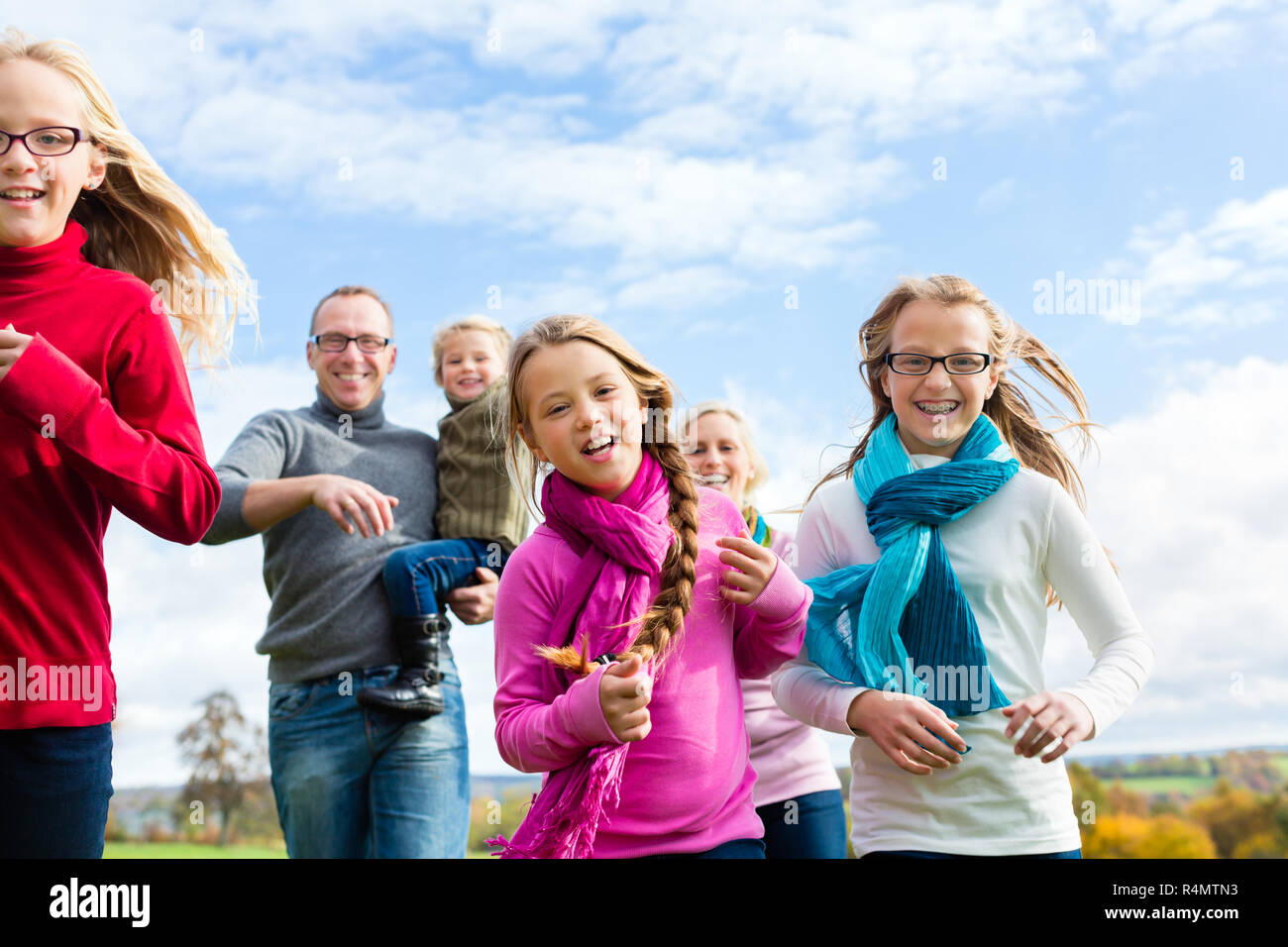 Family running through park in fall or autumn Stock Photo - Alamy