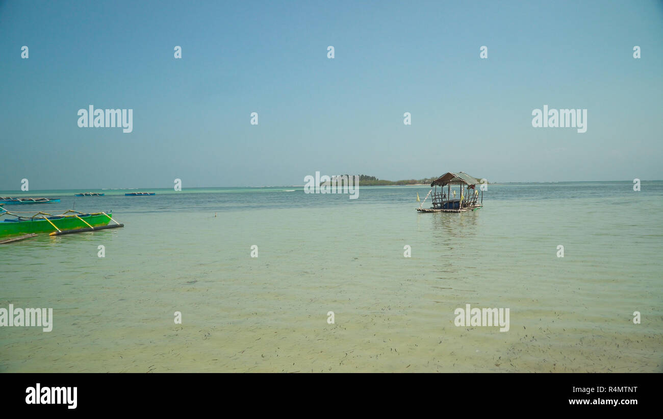 Tropical island with white sandy beach, palm trees in blue lagoon ...