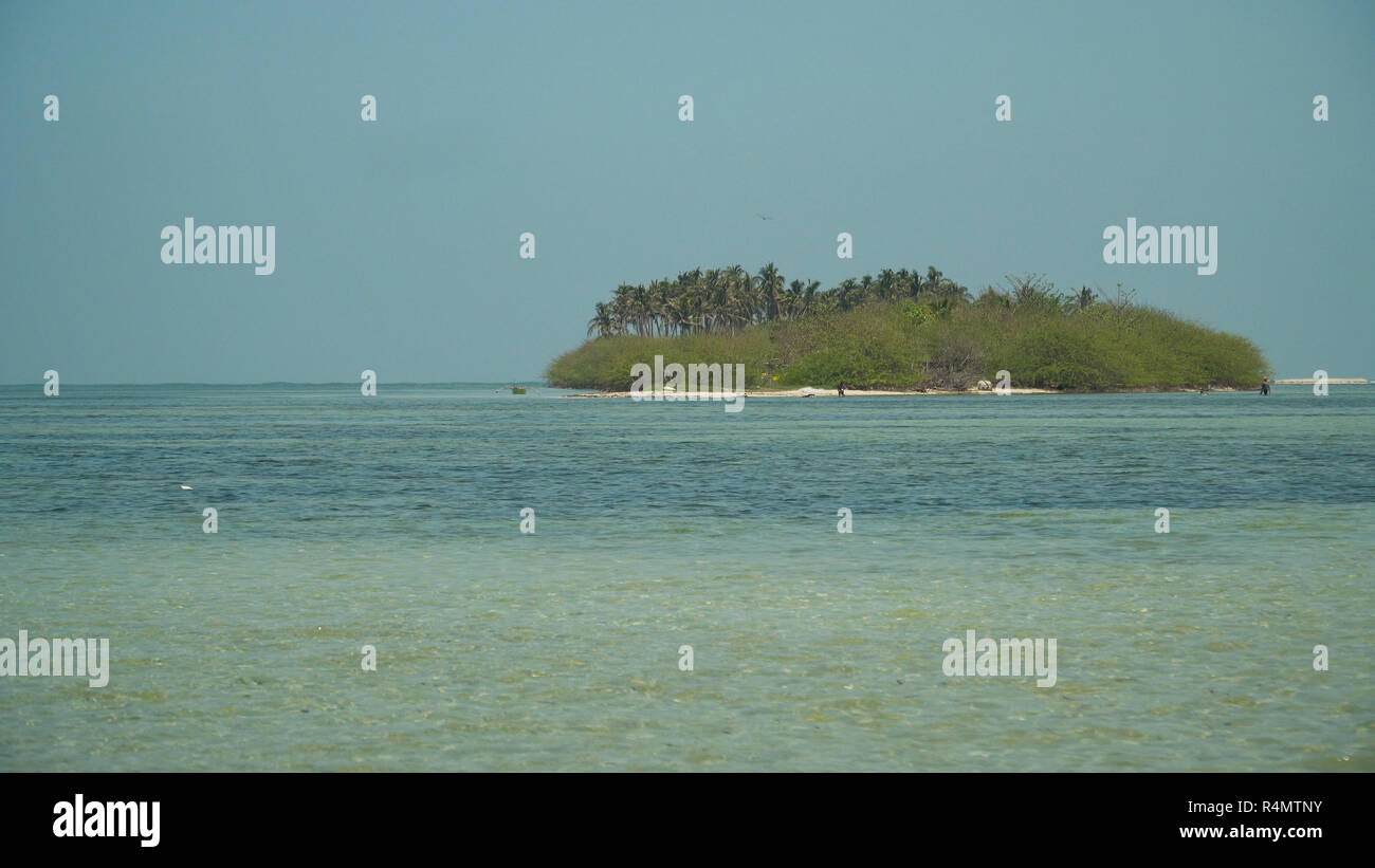 Tropical island with white sandy beach, palm trees in blue lagoon ...