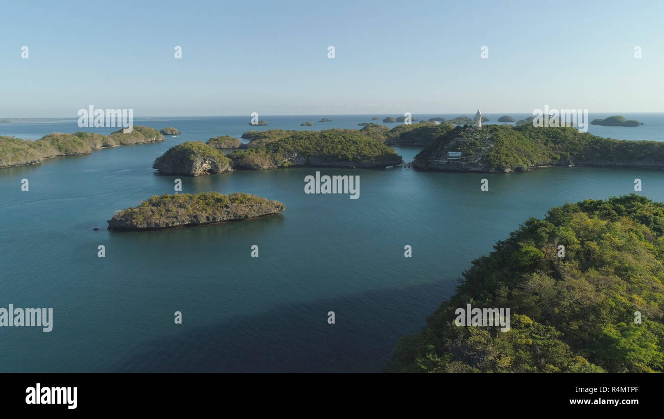 Small islands in Hundred Islands National Park with statue of Jesus ...