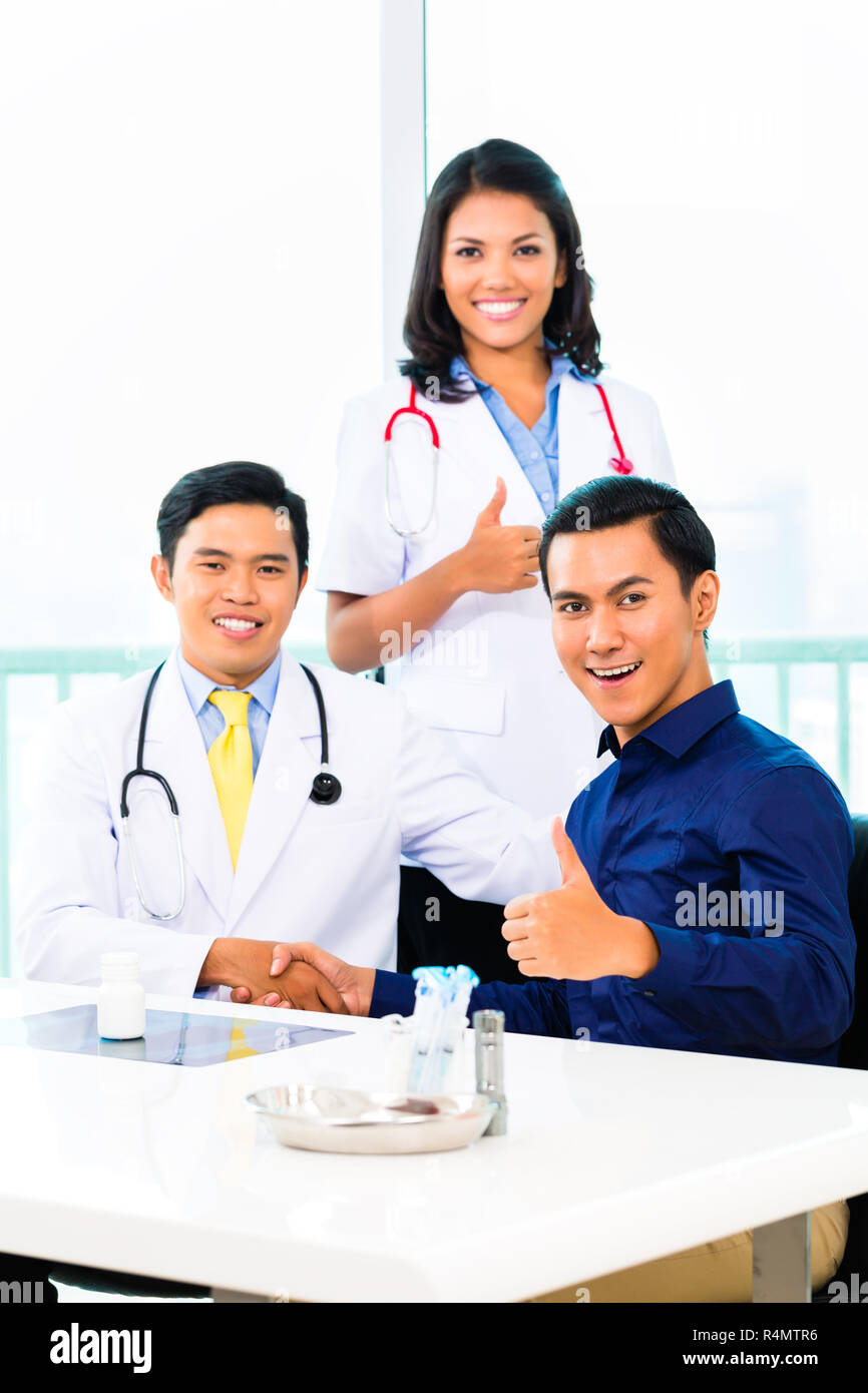 Asian Doctors with Patient in medical office or clinic Stock Photo - Alamy