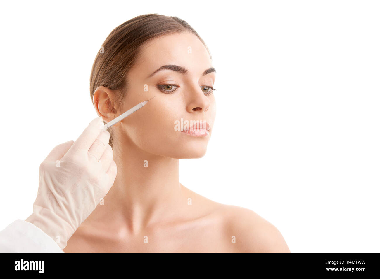 Portrait of an attractive young woman receiving botox treatment ...