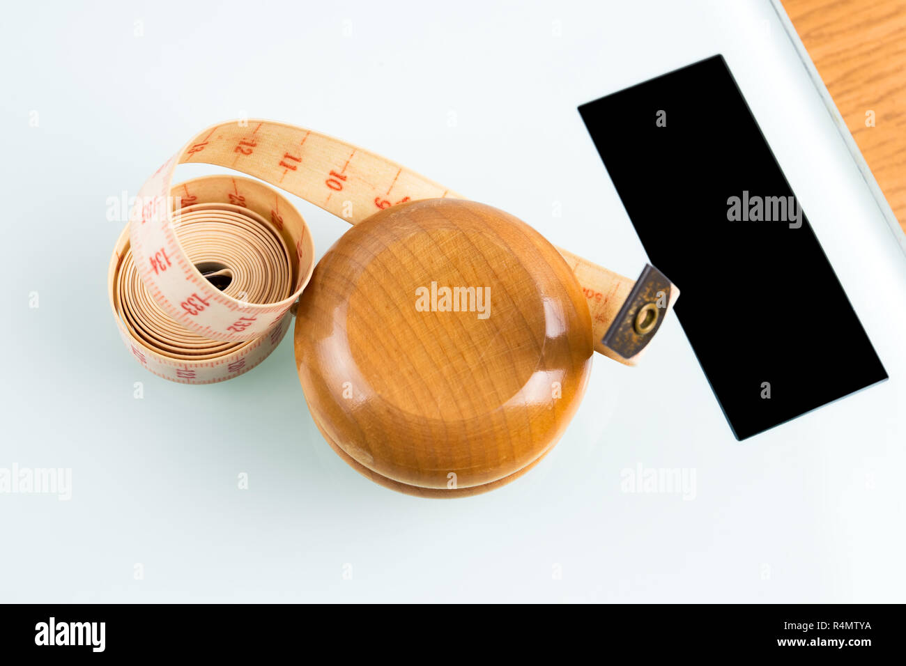 Yo-yo effect in diet concept. Wooden yoyo with centimeter measure ...