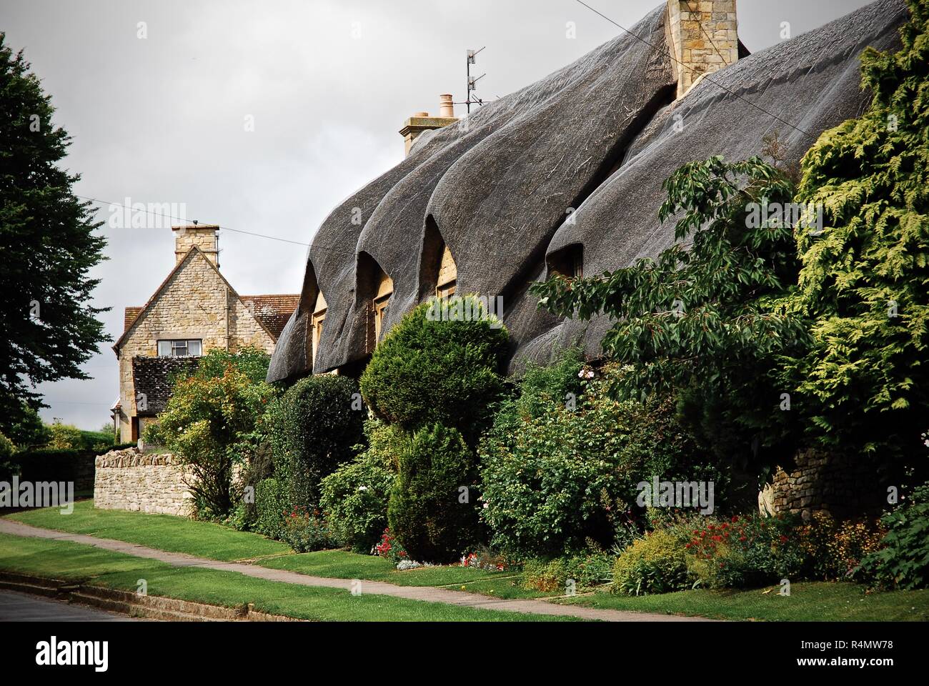 Traditional Cotswolds stone thatched cottage Stock Photo - Alamy