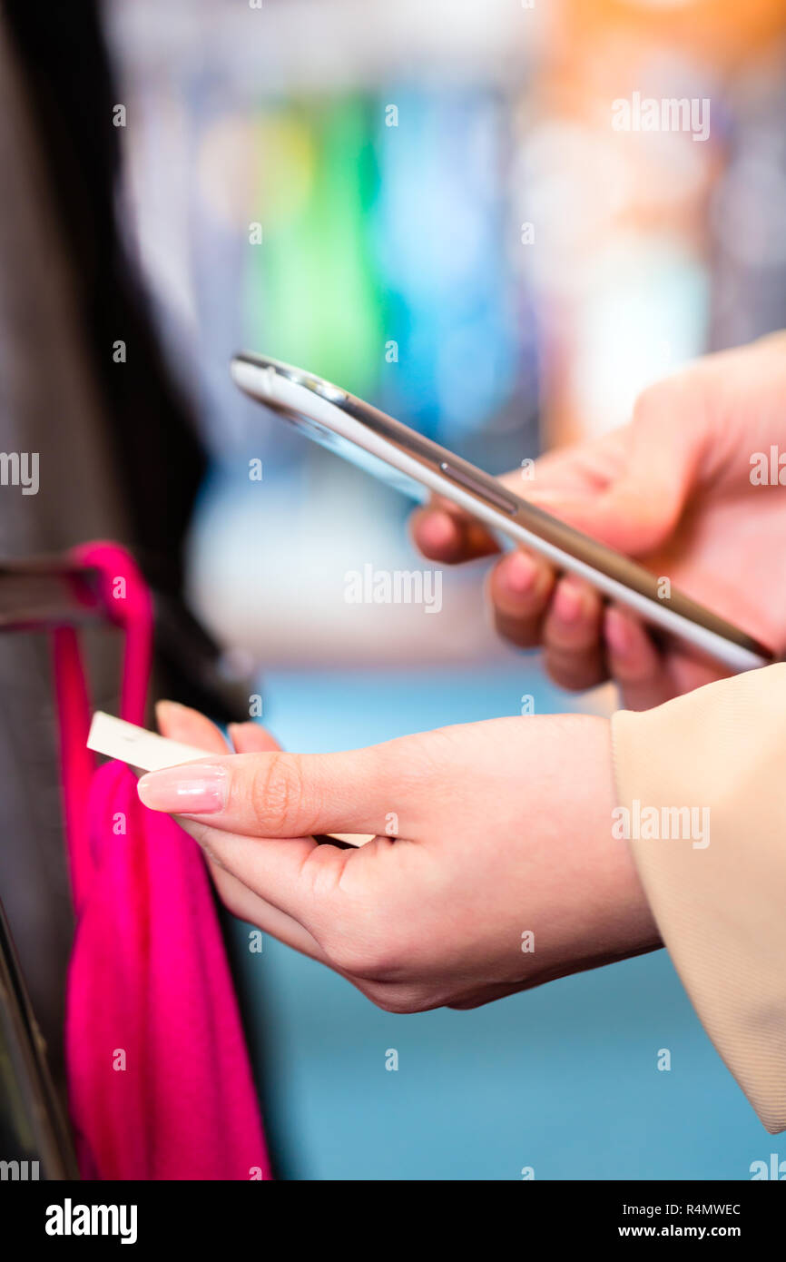 Woman price comparison for clothes in shop Stock Photo - Alamy