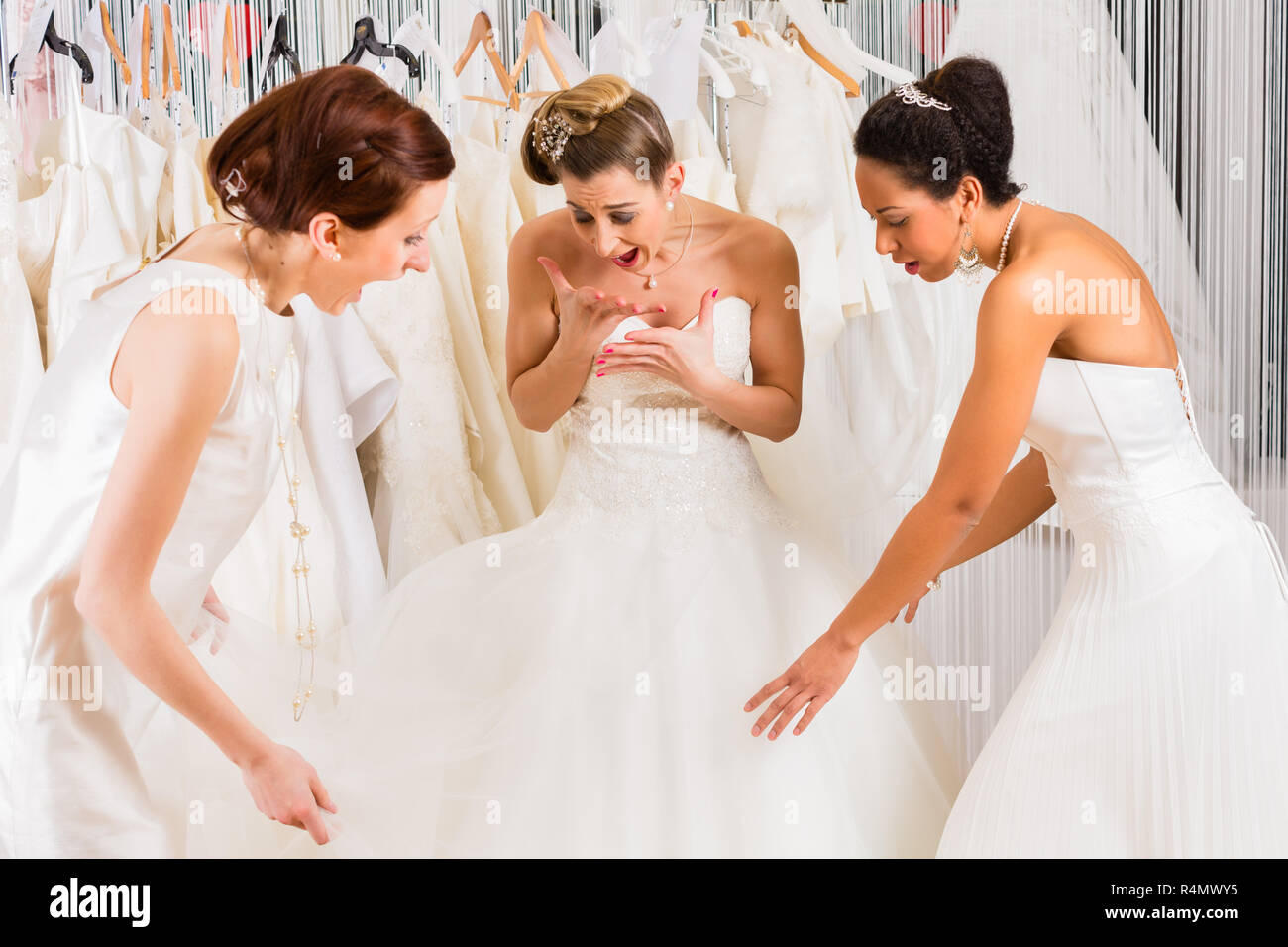 Women having fun during bridal dress fitting in shop Stock Photo - Alamy