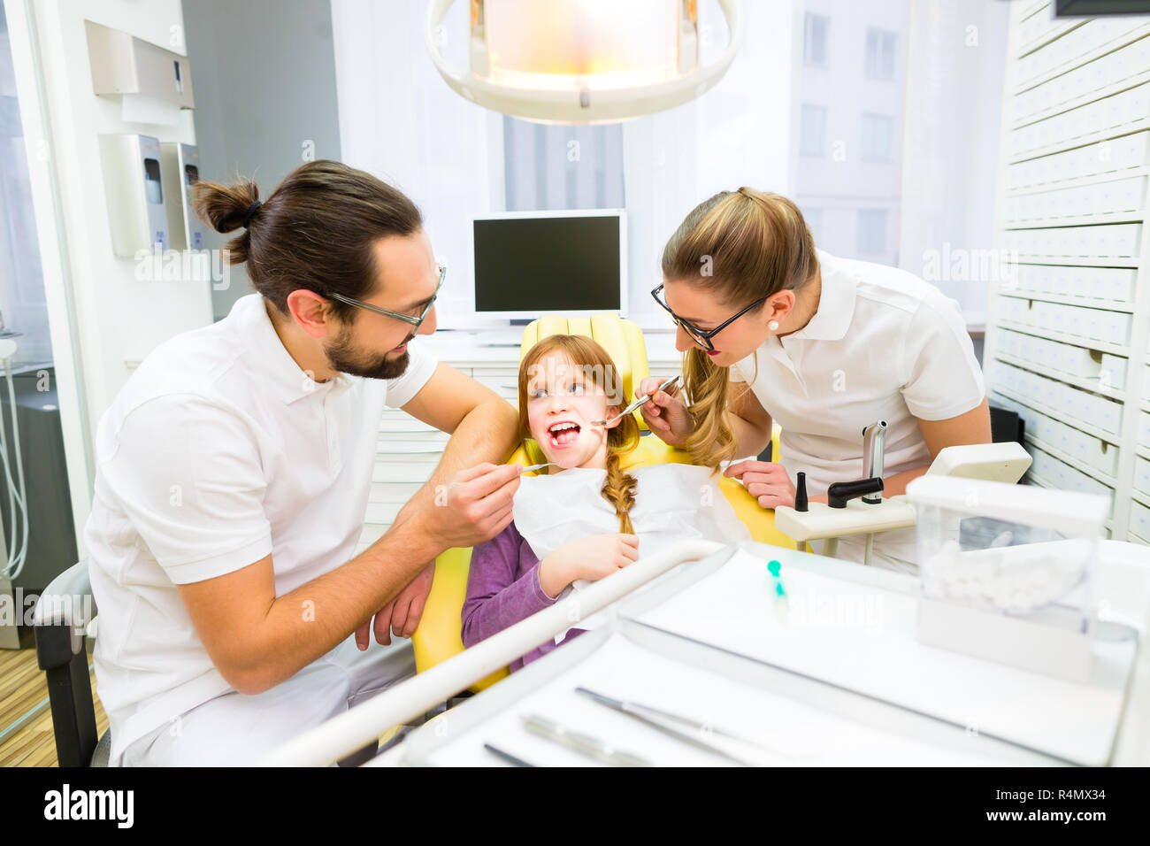 Dentist giving girl treatment in dental surgery Stock Photo - Alamy