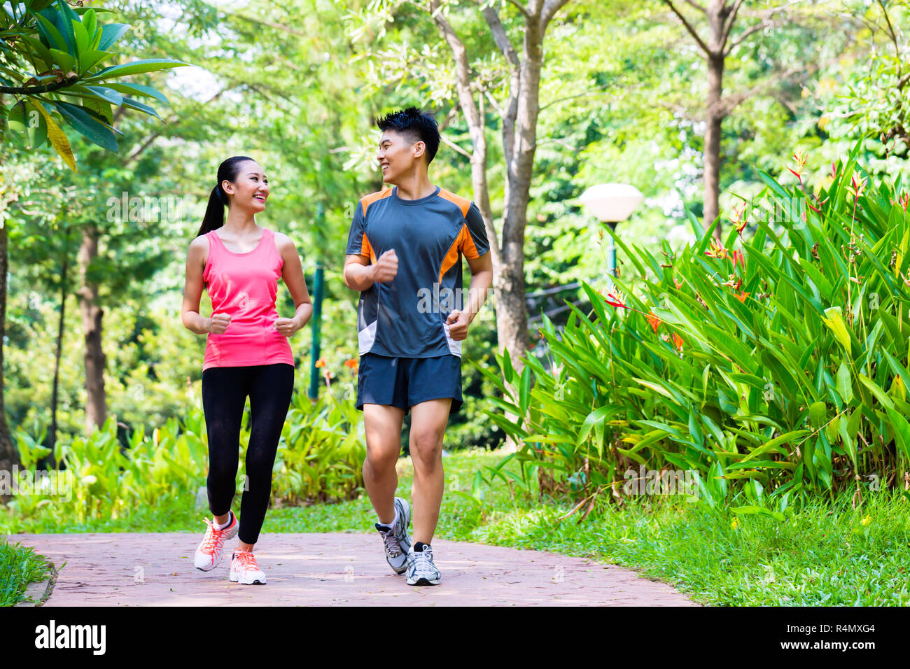 Asian Chinese man and woman jogging in city park Stock Photo - Alamy