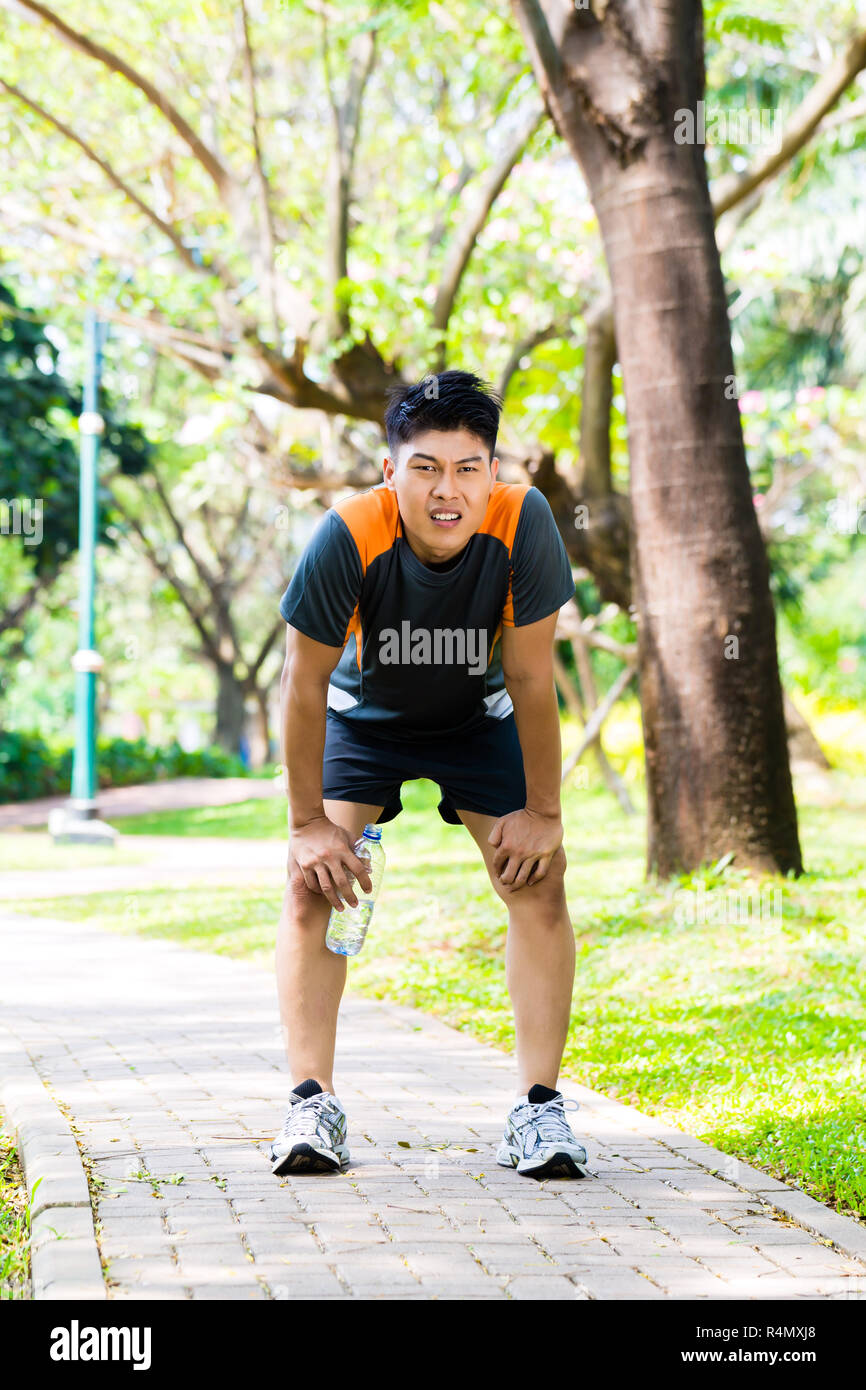 Asian man take breathless break of running Stock Photo - Alamy