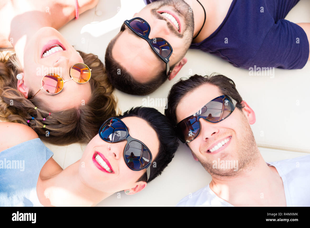 Friends lying in sand on beach Stock Photo - Alamy