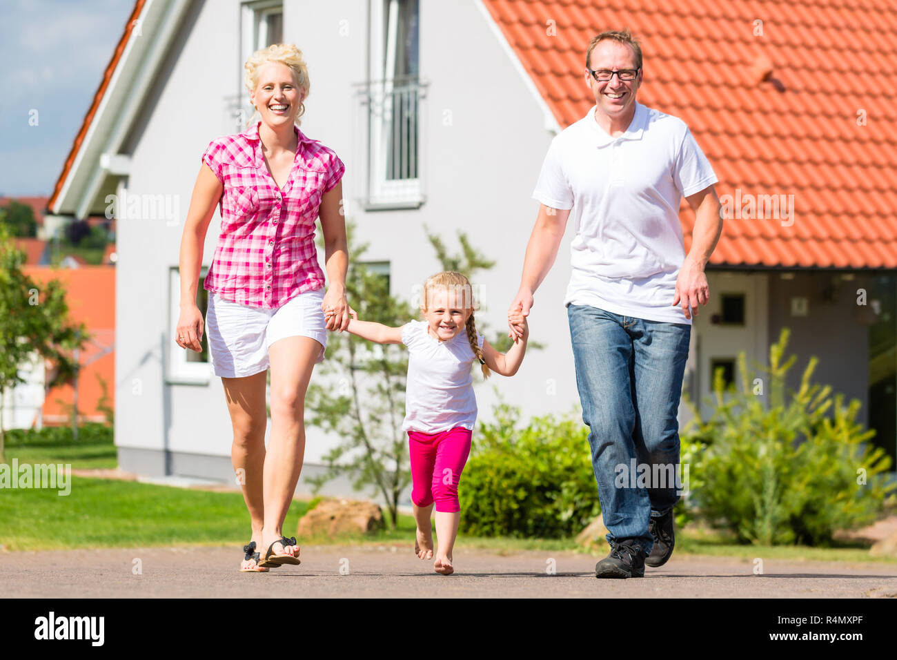 Family taking walk in front of home Stock Photo - Alamy