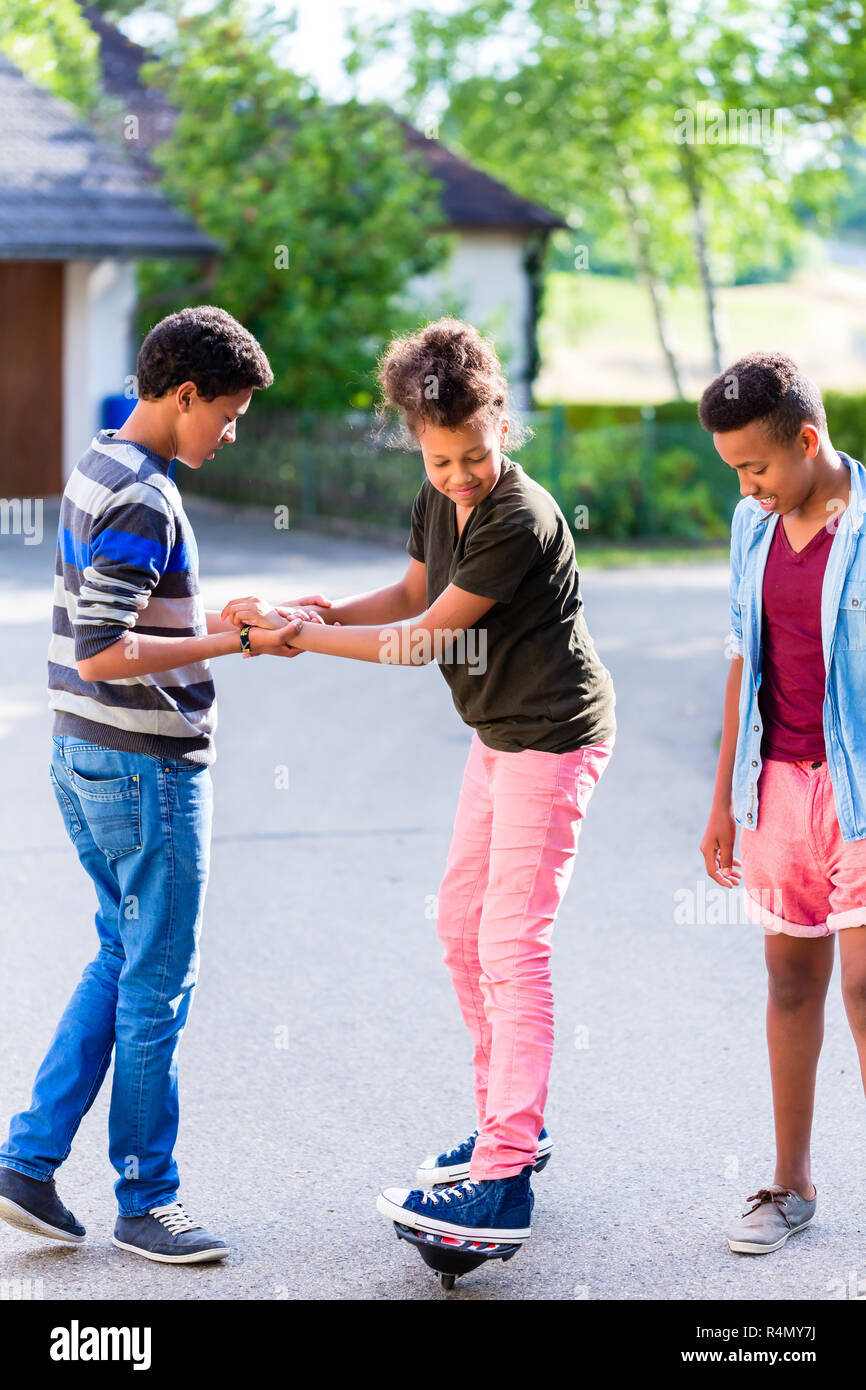 Three kids playing together with board Stock Photo - Alamy