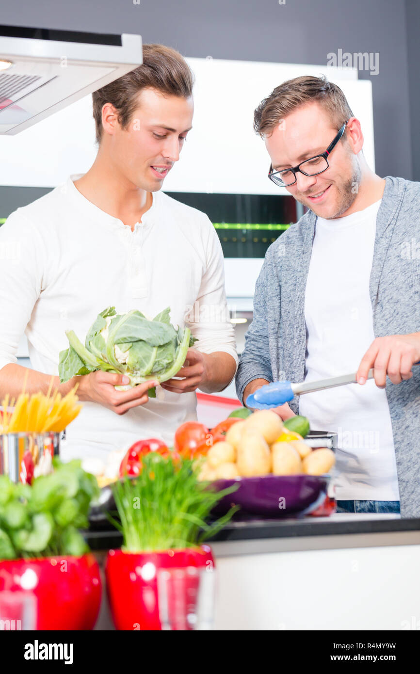 Friends cooking vegies and meat in domestic kitchen Stock Photo - Alamy