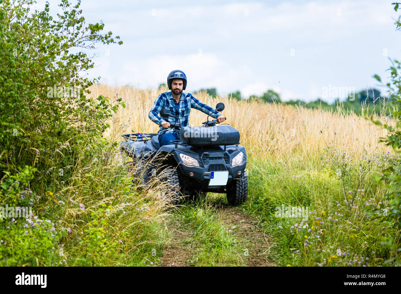 Man driving off-road with quad bike or ATV Stock Photo - Alamy